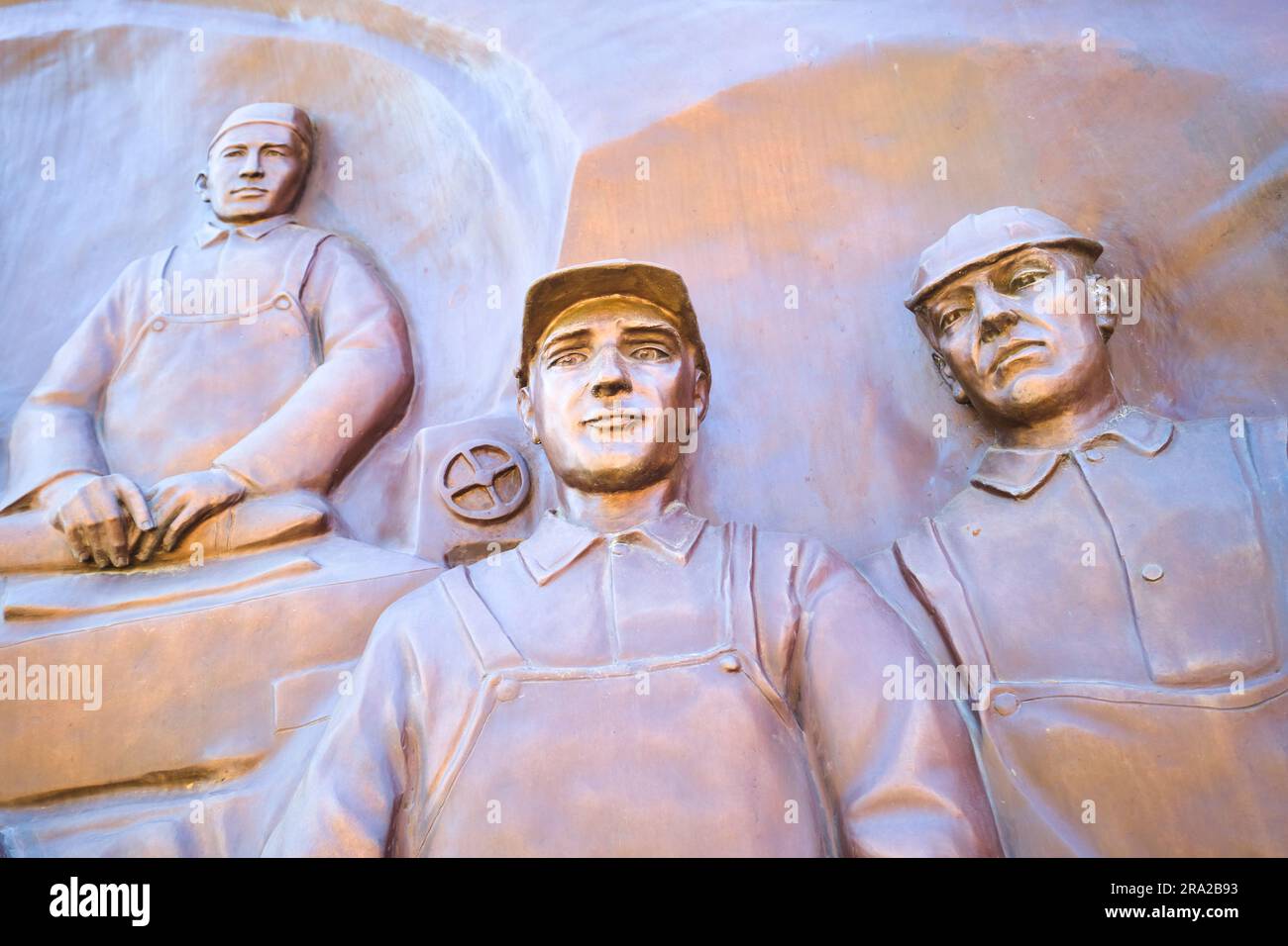 Portrait of three factory workers. Detail of the front entrance bronze frieze. At the Shon ...