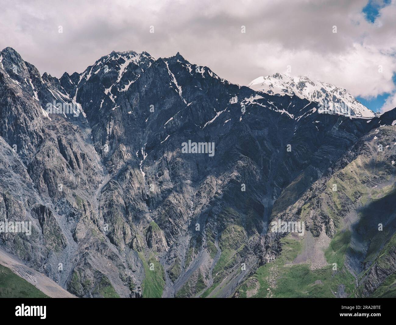 Cloudy and snowy mountains in summer Stock Photo - Alamy