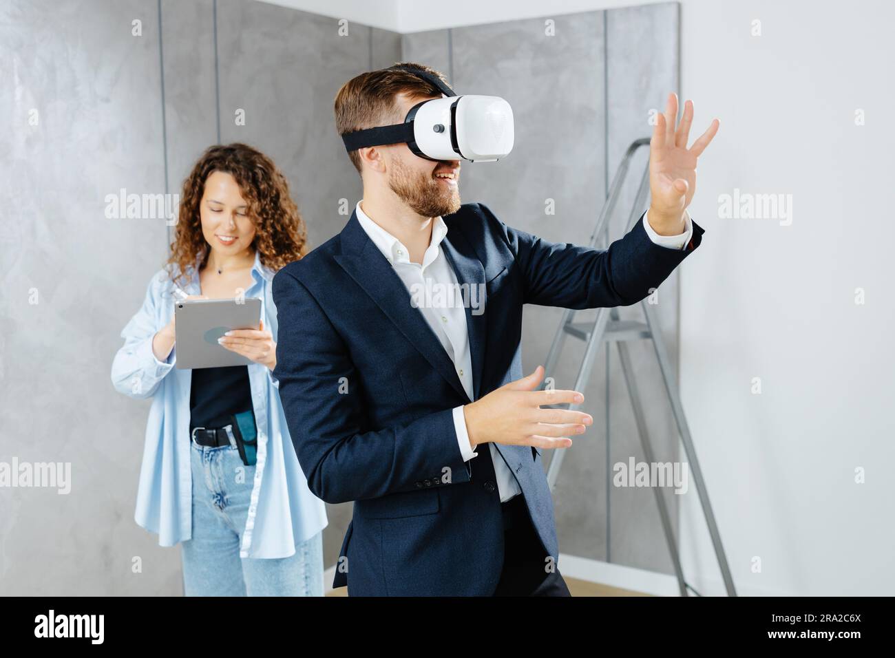 Man client wearing VR glasses imagining future interior standing with ...