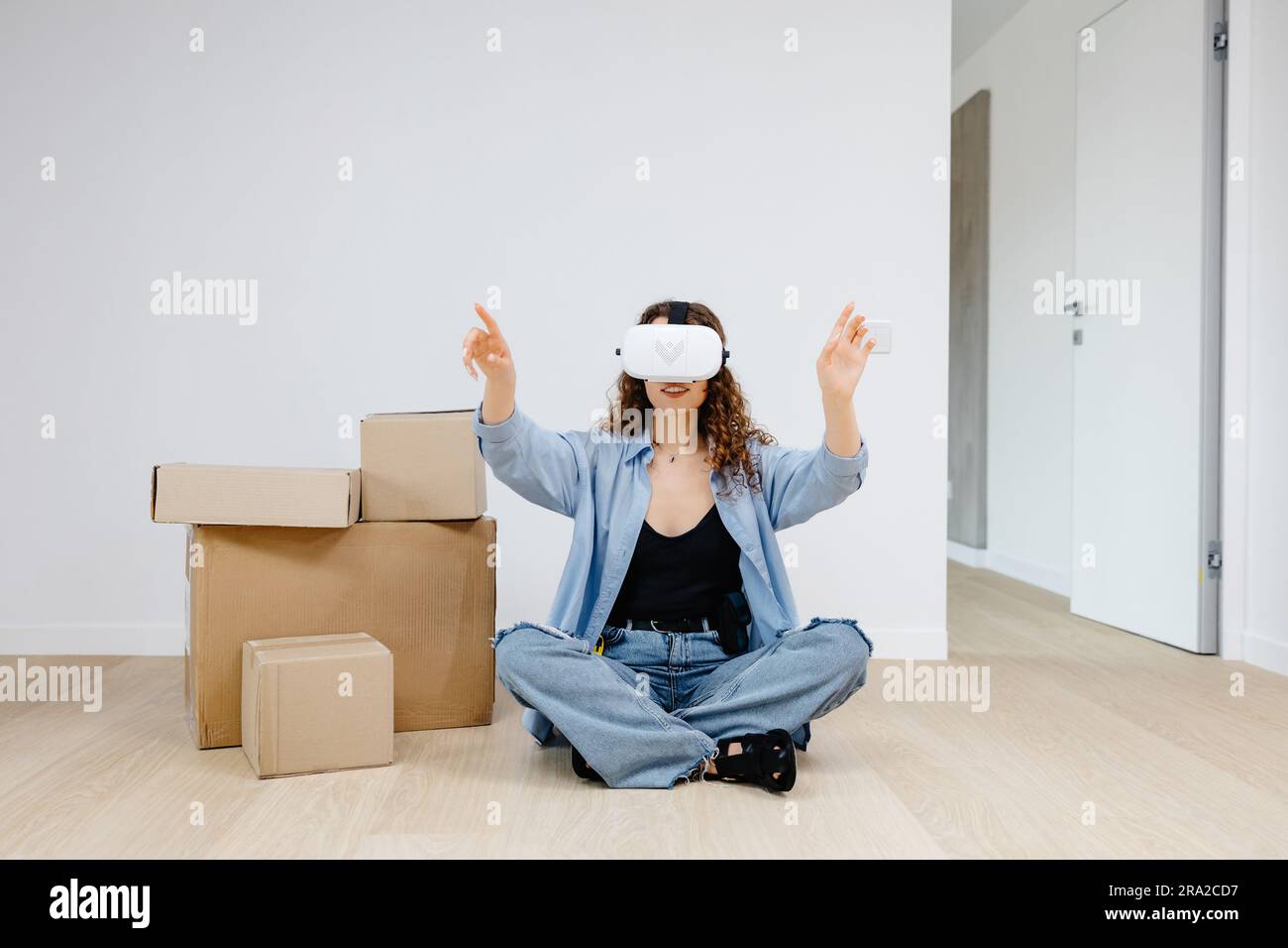Young woman in VR glasses using modern technology creating room design ...