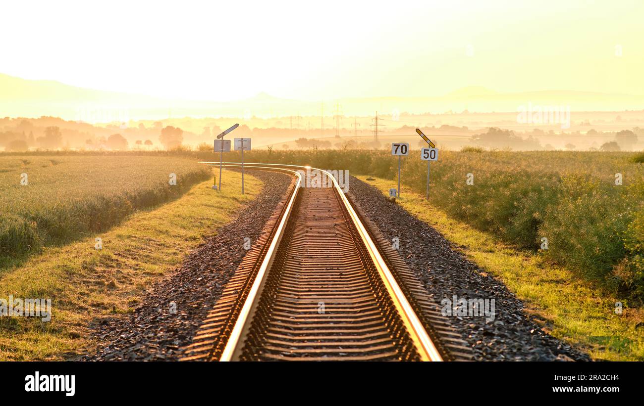 Railway tracks in morning at sunrise. Summer vacation rail road trip ...