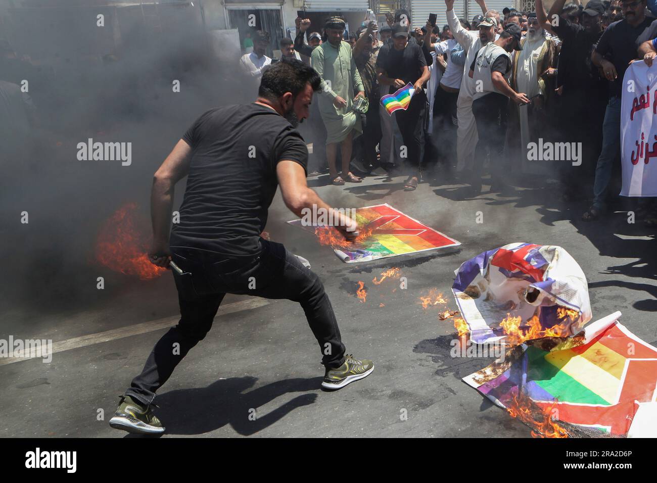 Supporters of Shiite Muslim leader Moqtada Sadr burn a rainbow flag, in ...
