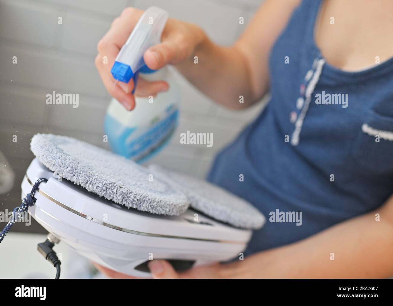 housewife woman applies glass washing liquid to the brushes of a ...