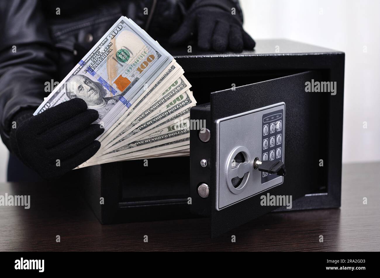 Thief steals dollars from the safe, close up Stock Photo - Alamy