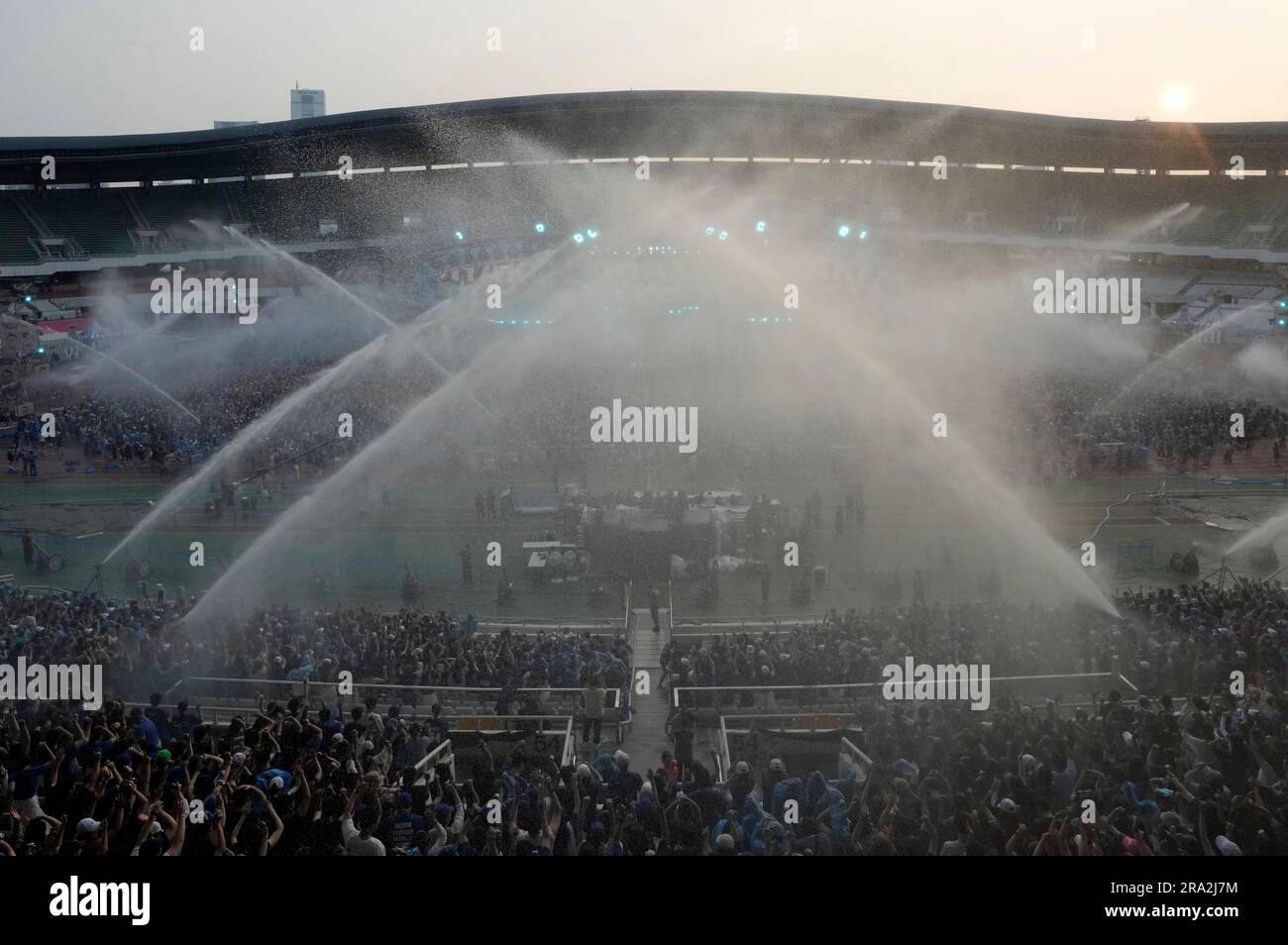 Fans cheer as water is sprayed on them during South Korean singer PSY's ...