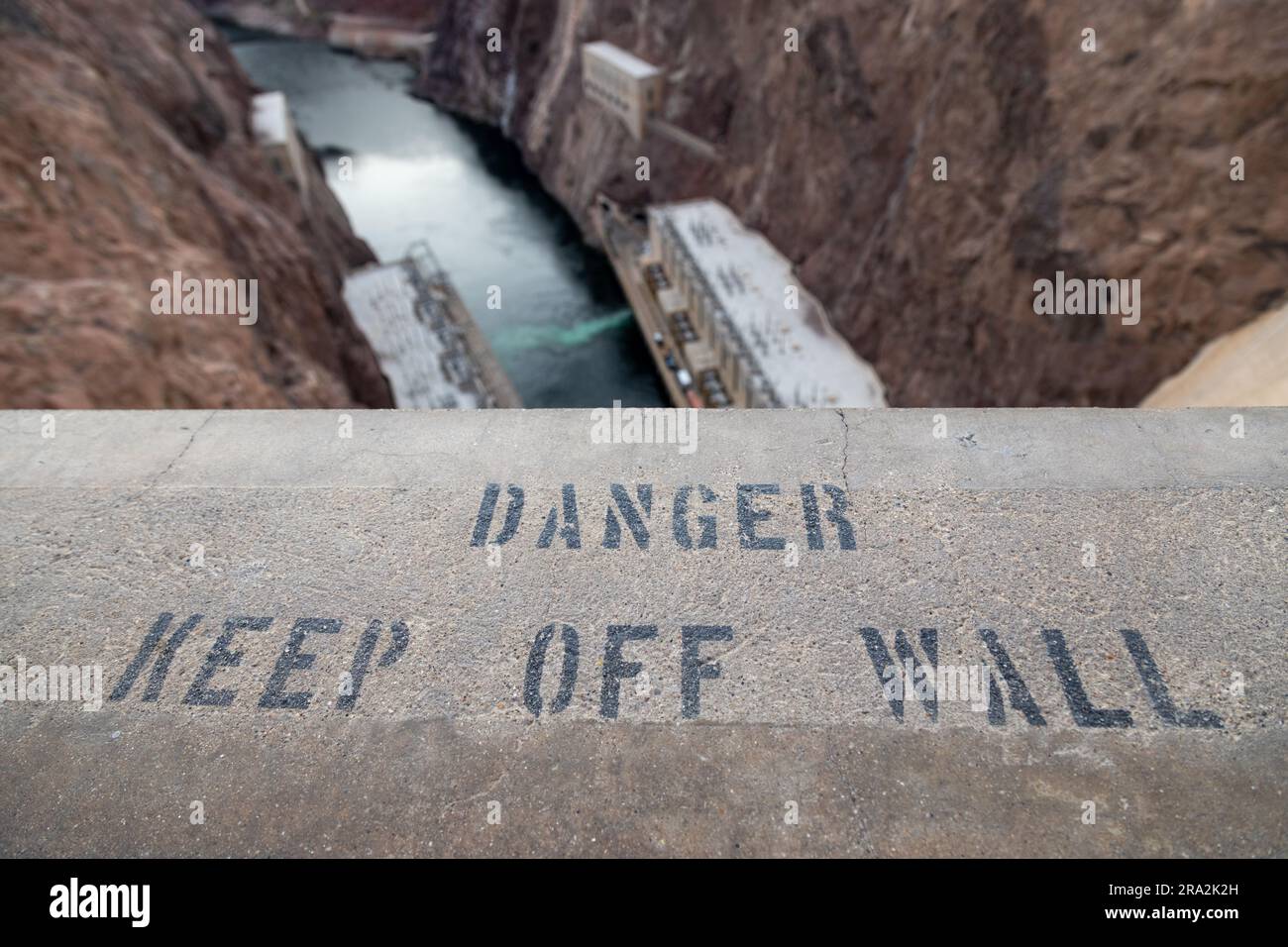 A brick wall with a warning sign painted on it that reads 'Danger: Keep ...