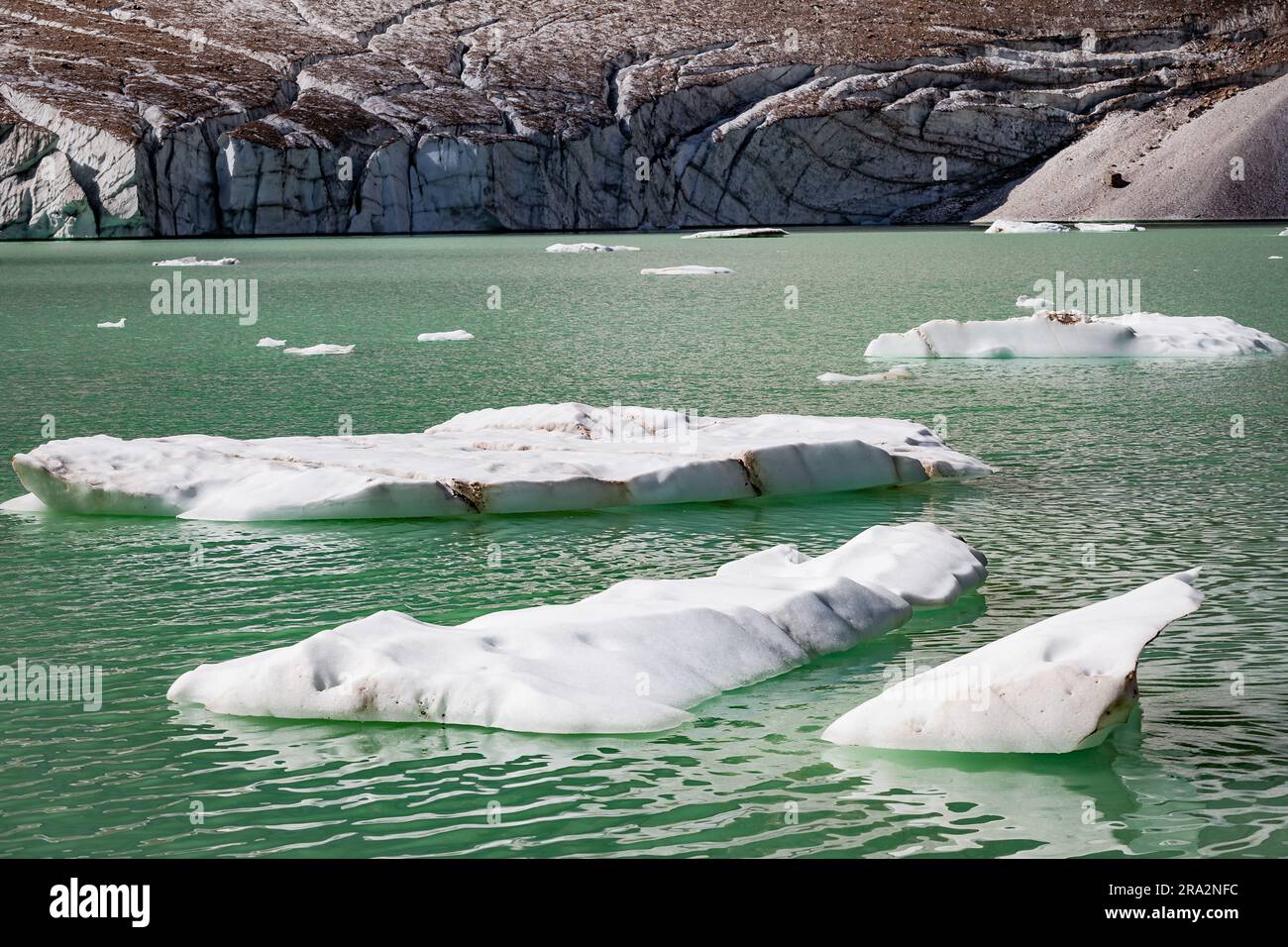 Glacier front with floating chunks of ice. Lines carved into the front ...