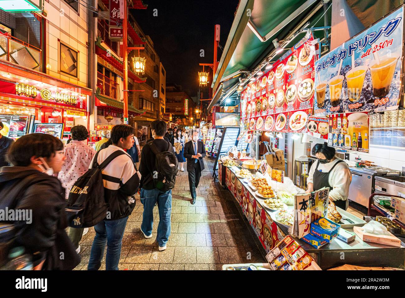 Busy food stalls and restaurants on both sides of the crowded main ...