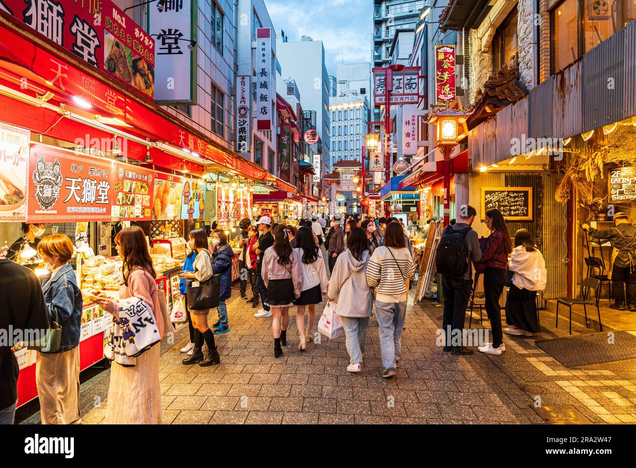 Chinatown in Kobe at night. View along narrow pedestrian street filled ...