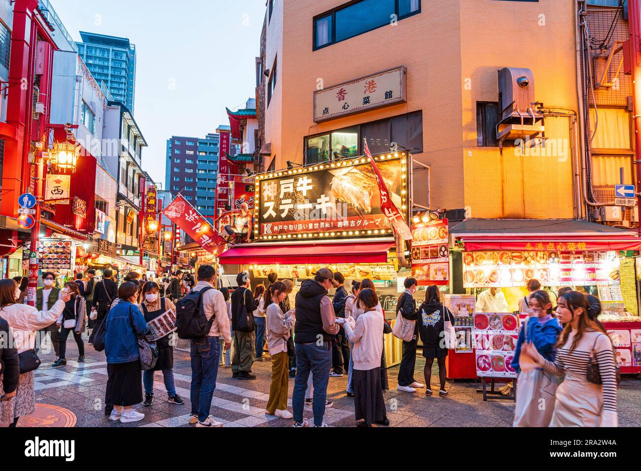 Japanese people queuing at night time to buy from a very popular Kobe ...