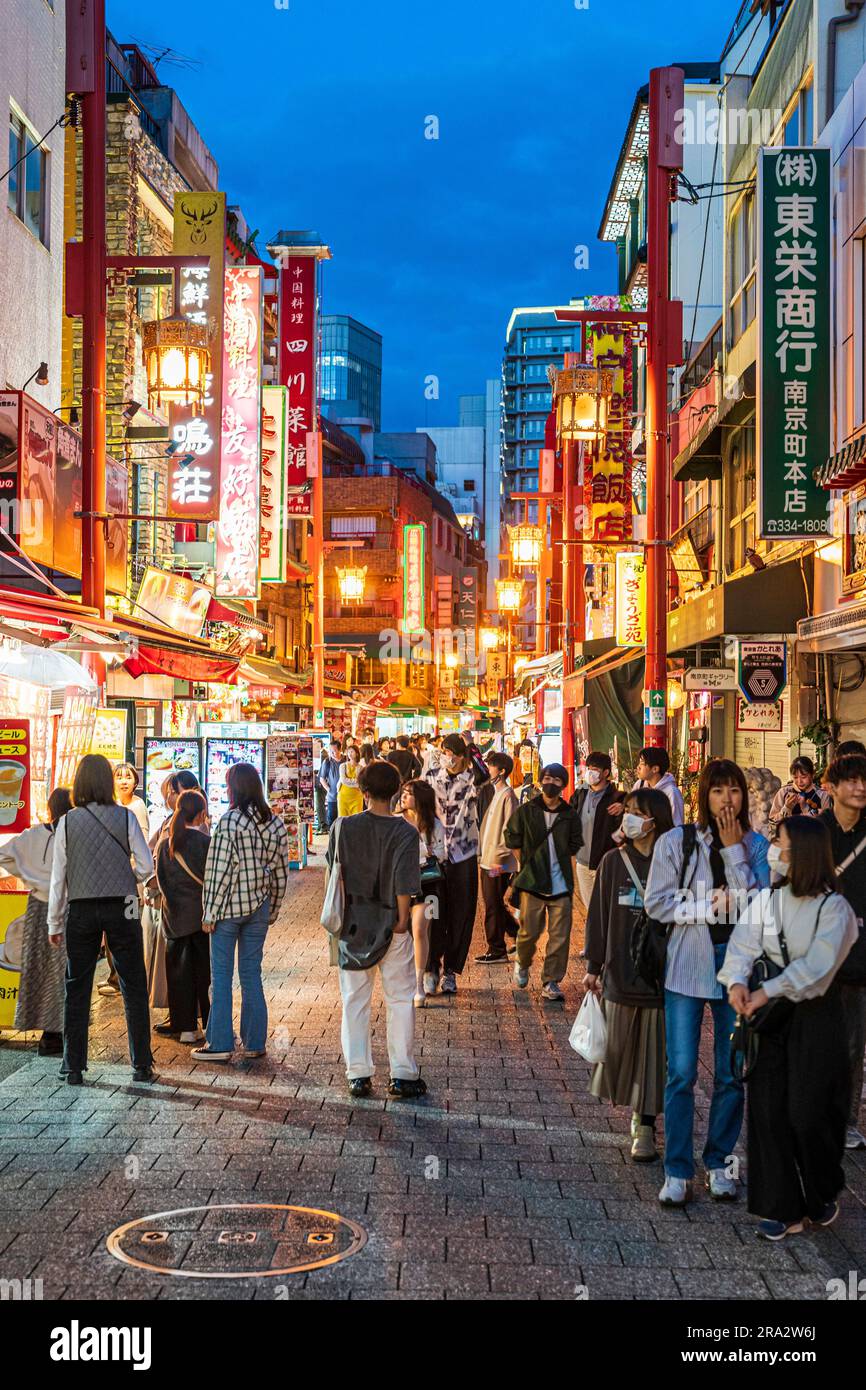 Chinatown in Kobe at night. View along narrow pedestrian street filled ...