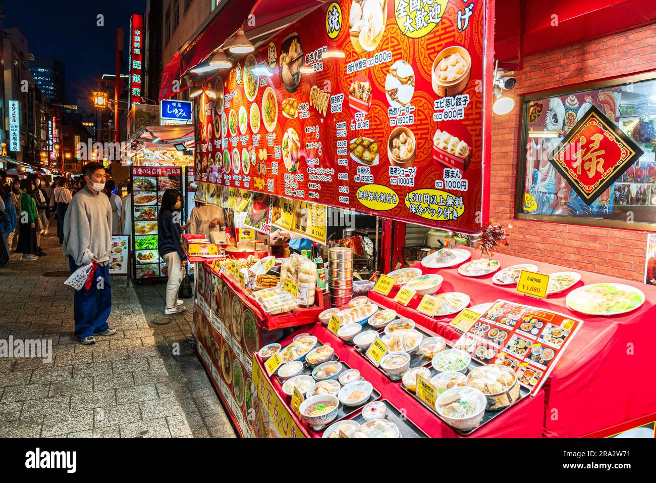 Row of Chinese food stall with plates of various foods such as ...
