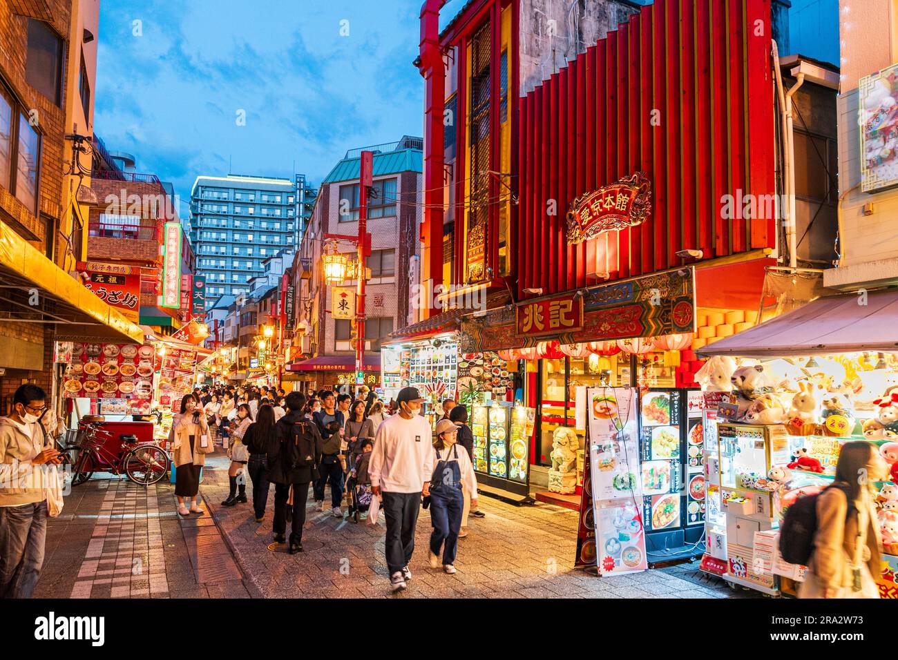 Chinatown in Kobe at night. View along narrow pedestrian street filled ...