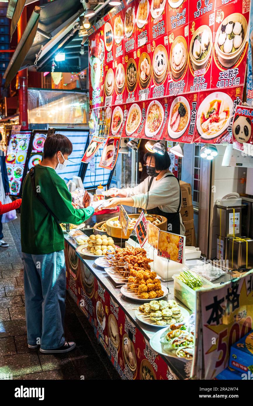 Woman serving young man at a Chinese food stall selling foods on a ...