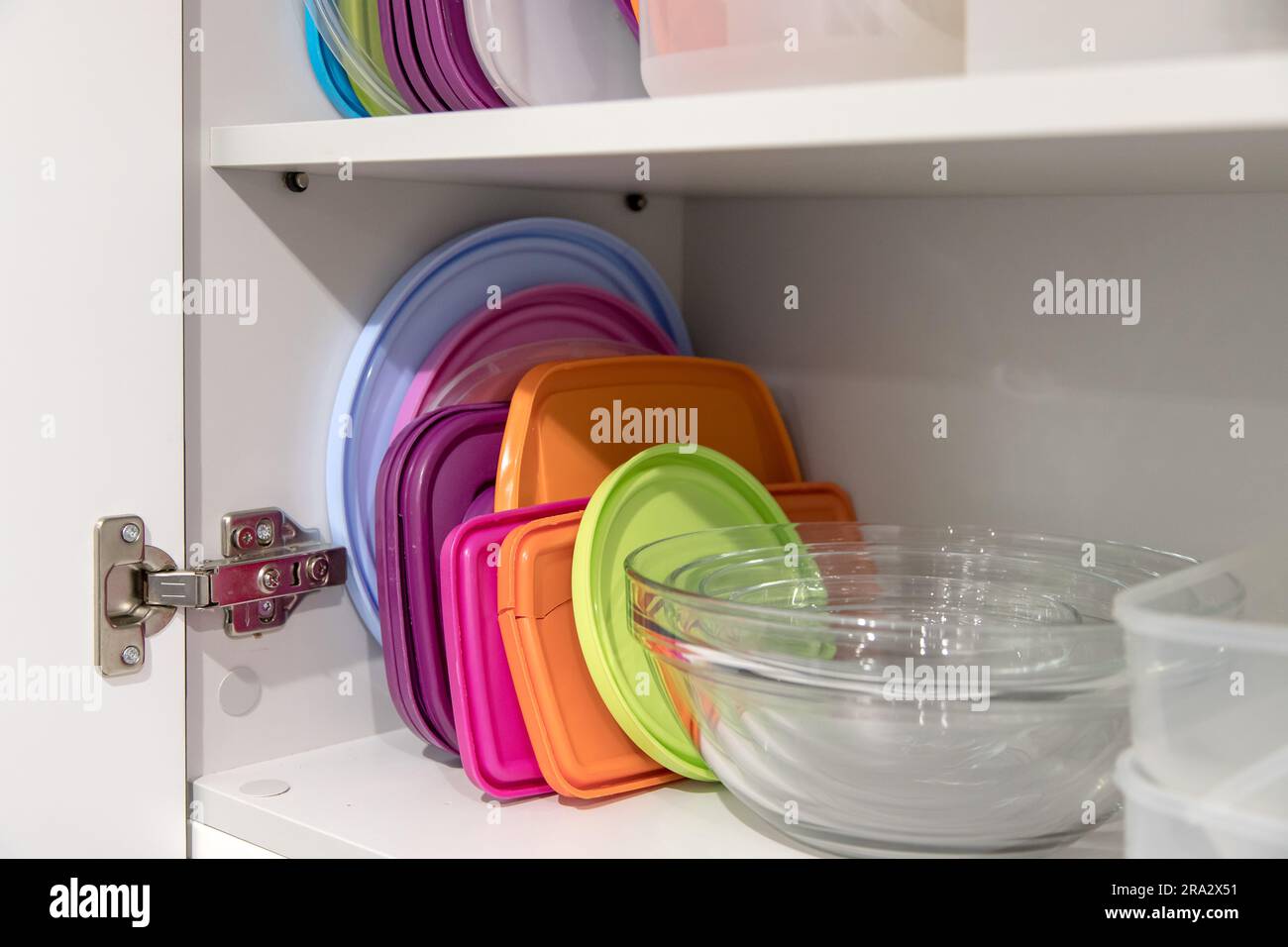 Open kitchen cupboard full of plastic and glass containers inside Stock ...