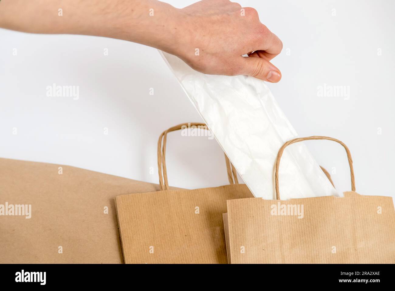 Action, person putting things inside kraft paper bag. Conceptual image ...