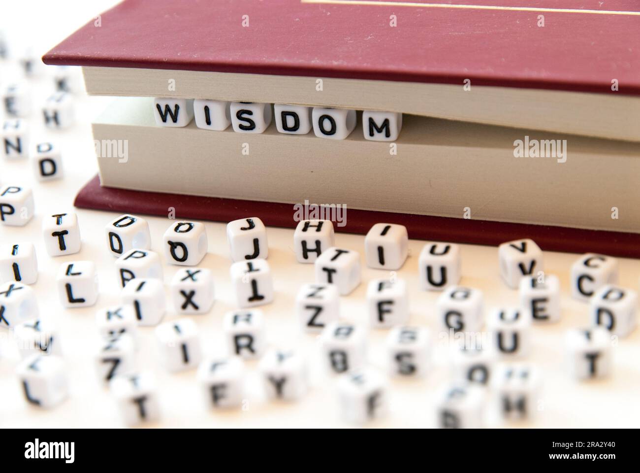 Word wisdom written with letters between a book pages white background ...