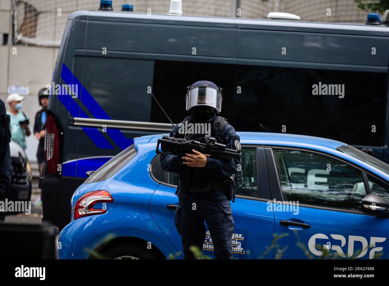 A police officer seen holding his weapon during the march for Nahel ...