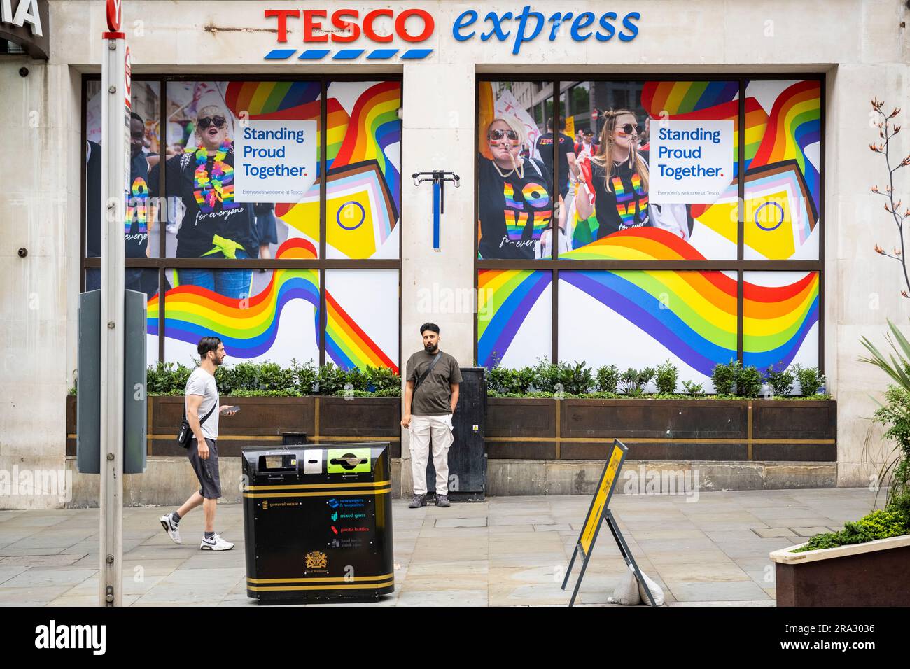London, UK. 30 June 2023. People next to rainbow coloured decorations ...