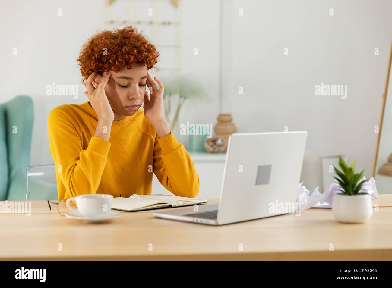 African woman touching temples experiencing stress. Girl at home office ...