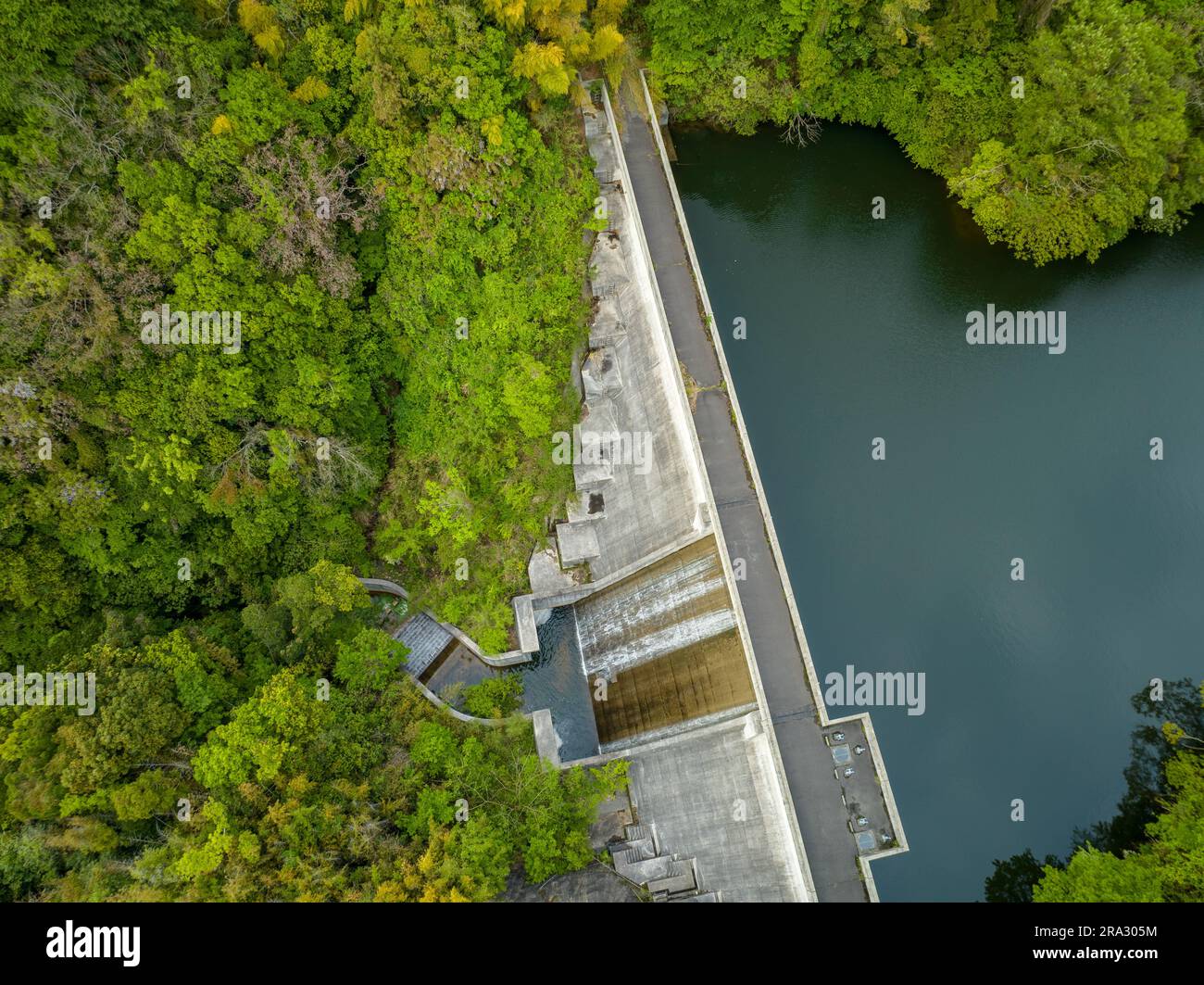 Aerial view of concrete dam and reservoir in green forest Stock Photo ...