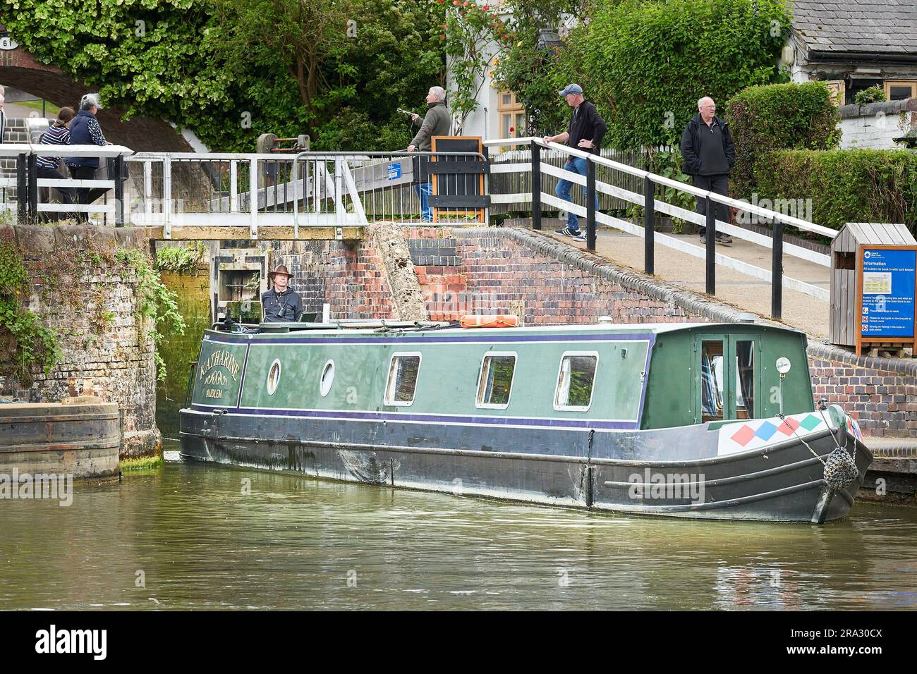 A man drives a narrow boat out of the lowest lock on Foxton locks along ...