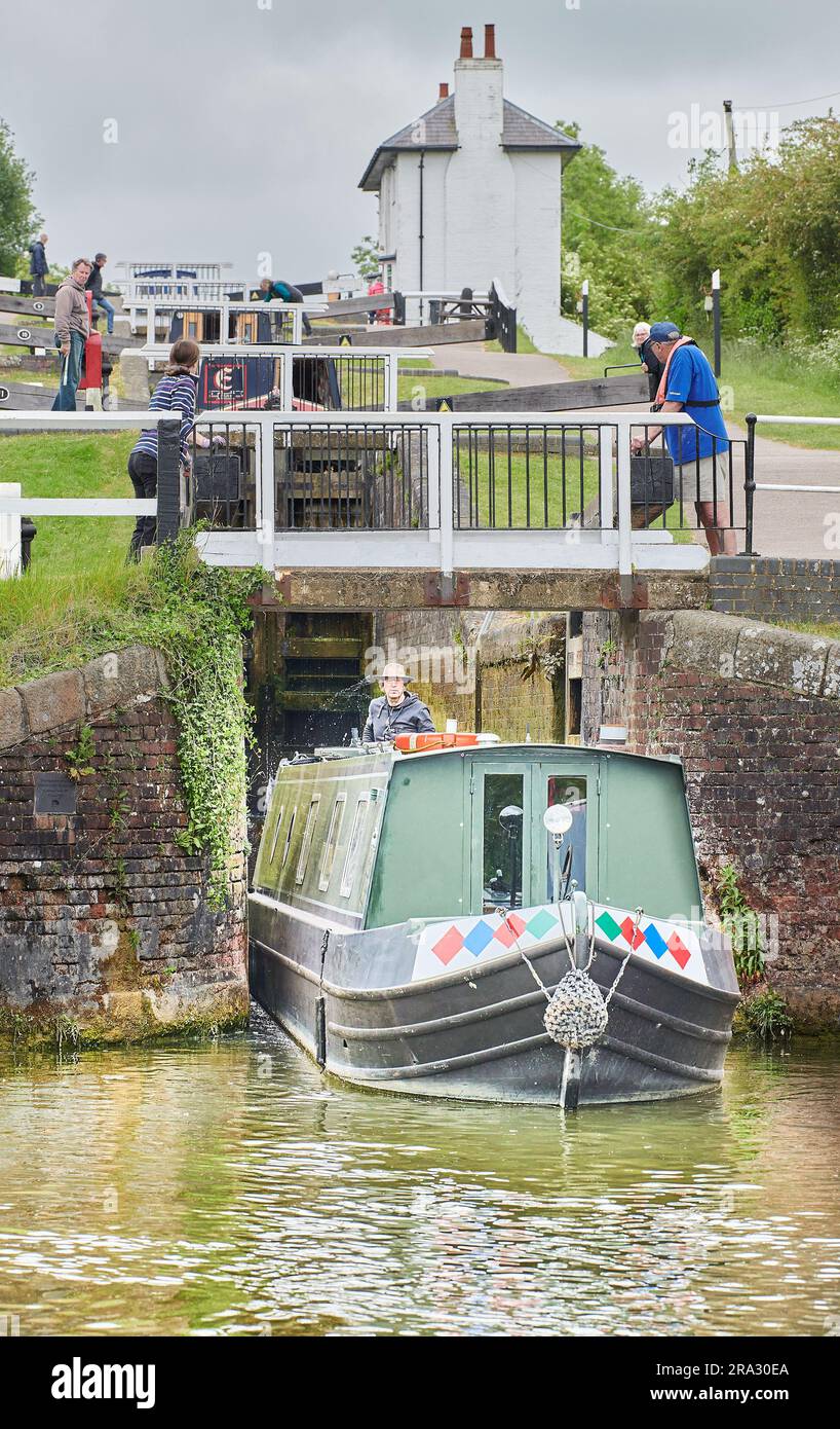 A man drives a narrow boat out of the lowest lock on Foxton locks along ...