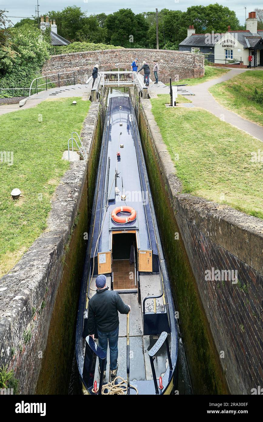 A man steers a narrow boat on its way down Foxton locks along the Grand ...