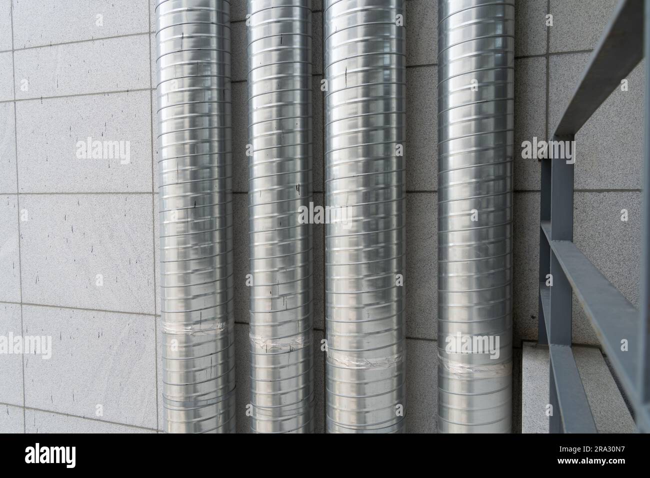 Ventilation tubes that go up to the roof on the outer wall of a high ...