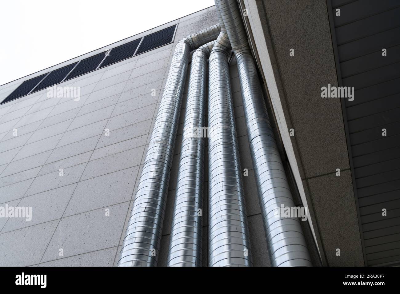 Ventilation tubes that go up to the roof on the outer wall of a high ...