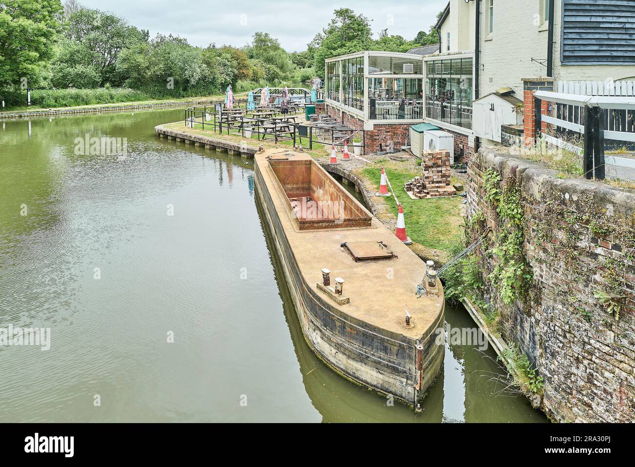 A disused barge boat moored at Foxton Locks Inn next to the lowest lock ...