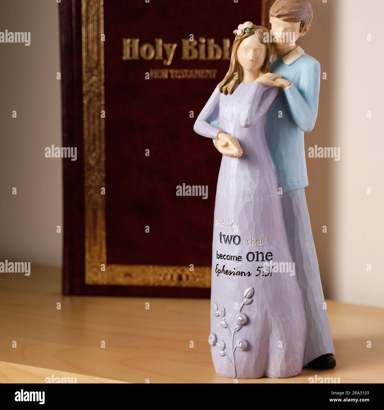 Ceramic ornament of a man holding a woman in front of a Bible. The ...