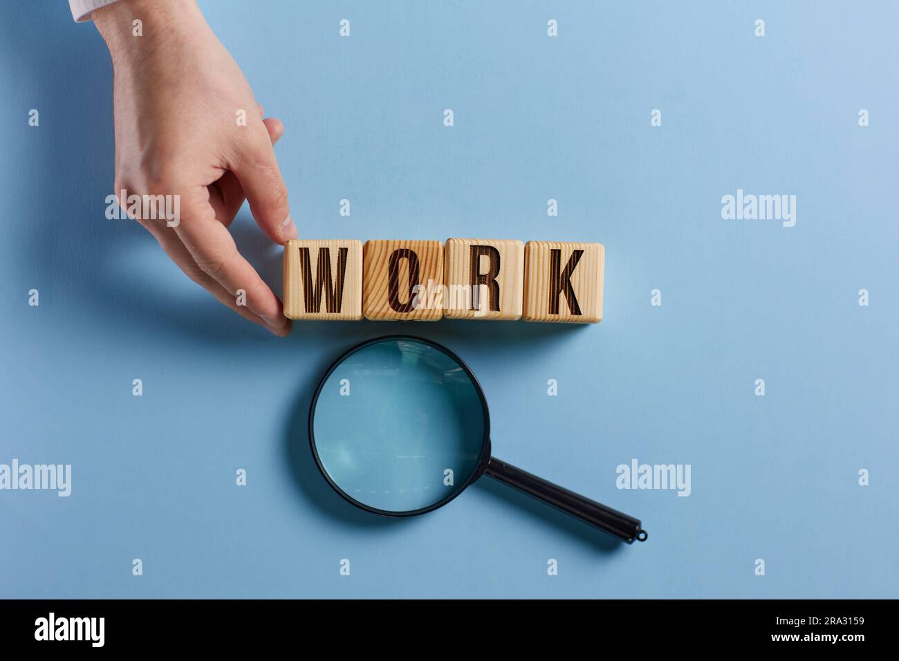 The word work is inscribed in wooden cubes. blue background Stock Photo ...