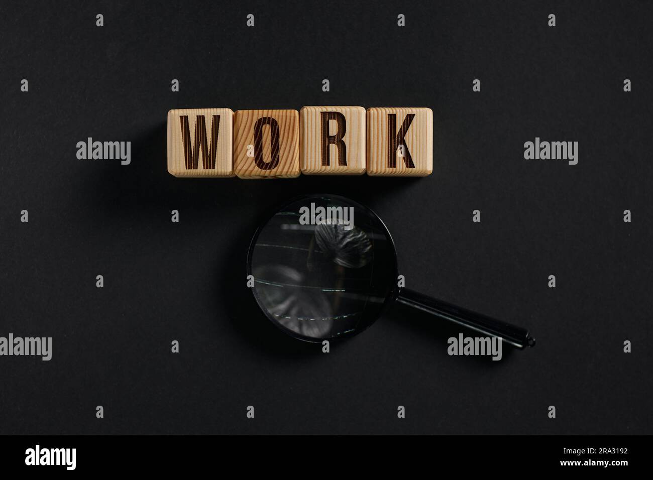 The word WORK is written in wooden cubes in black letters on a yellow ...