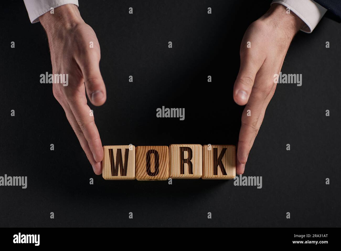 The word WORK is written in wooden cubes in black letters on a yellow ...