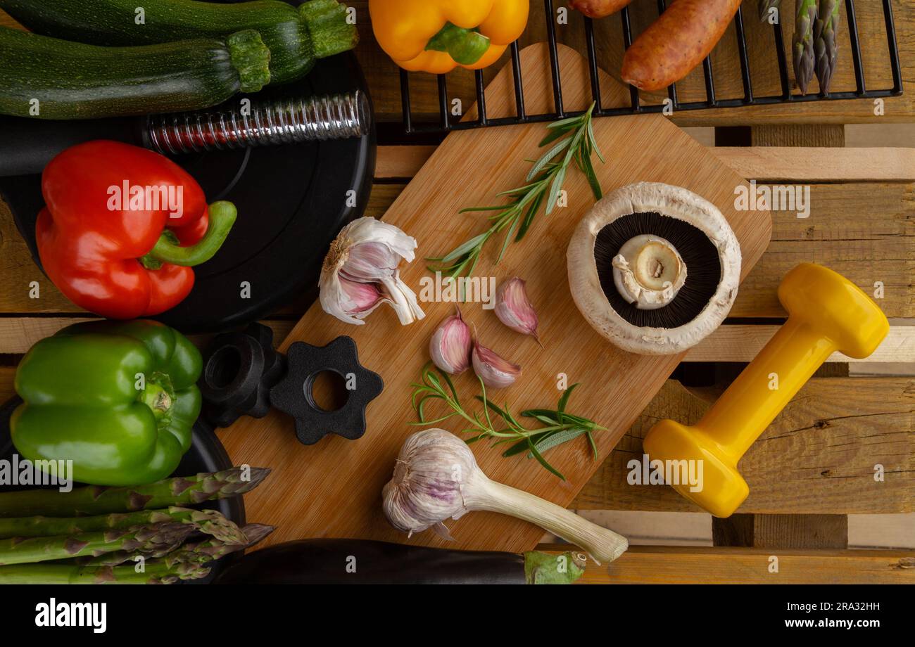Gym dumbbells, vegetables, sausages for grill cooking. Fit barbecue ...