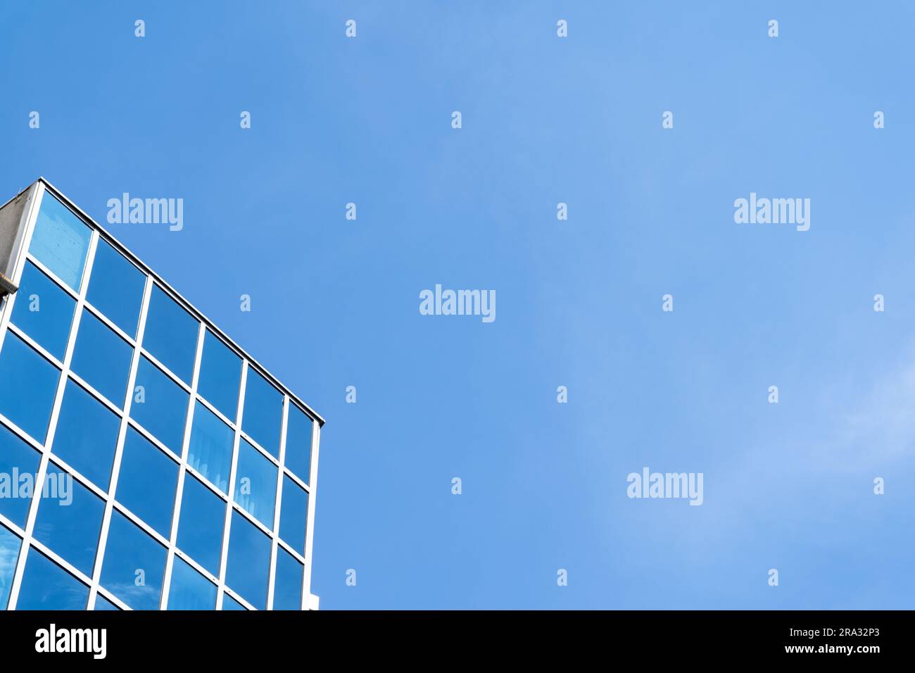 Modern office building with a glass facade and copy space on a blue sky ...