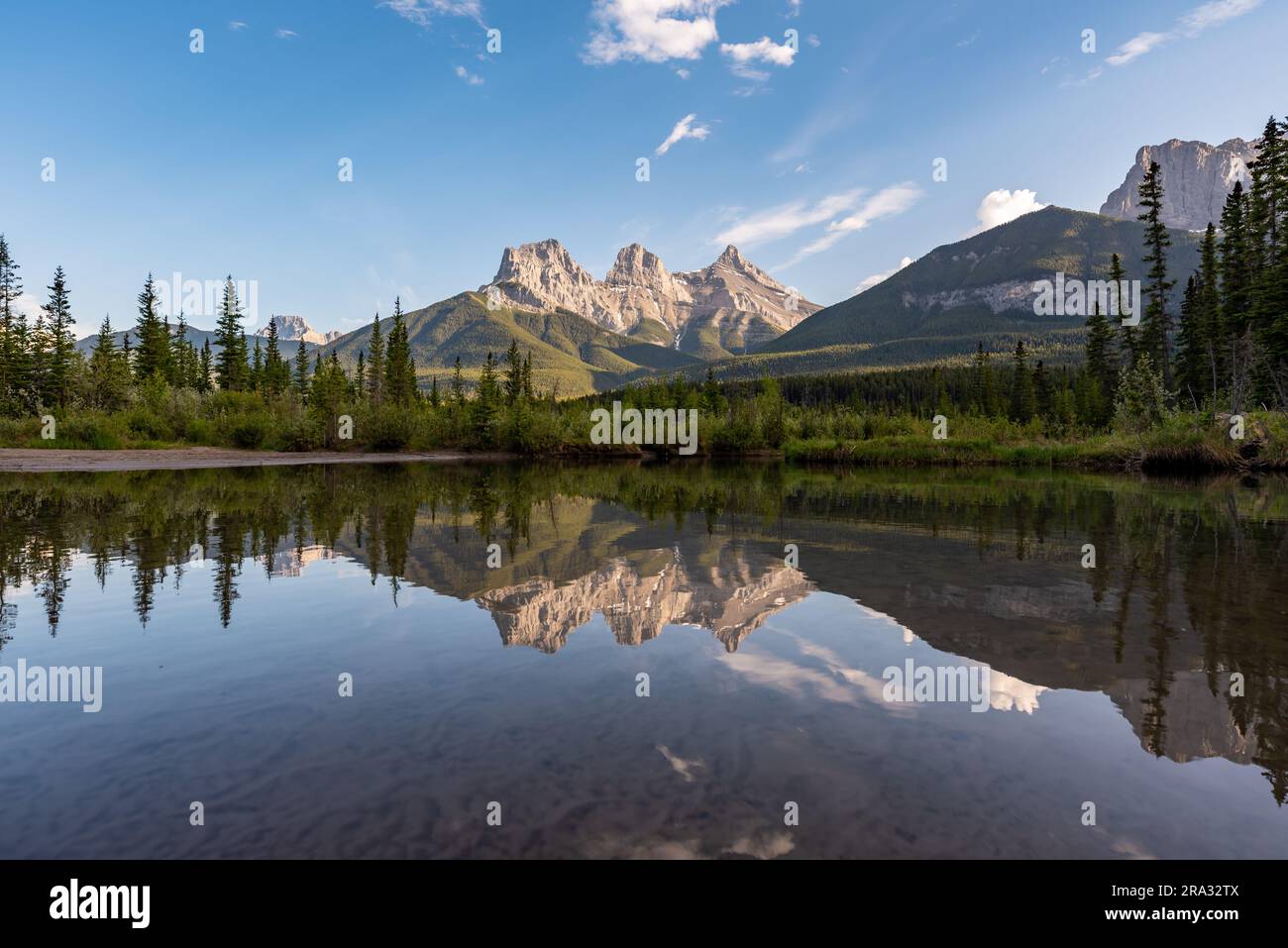 Three Sisters in Canmore seen at golden hour, sunset on blue sky day ...