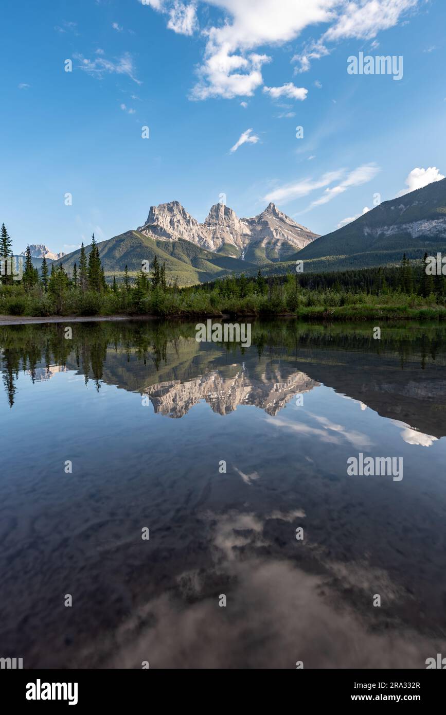 Three Sisters in Canmore seen at golden hour, sunset on blue sky day ...