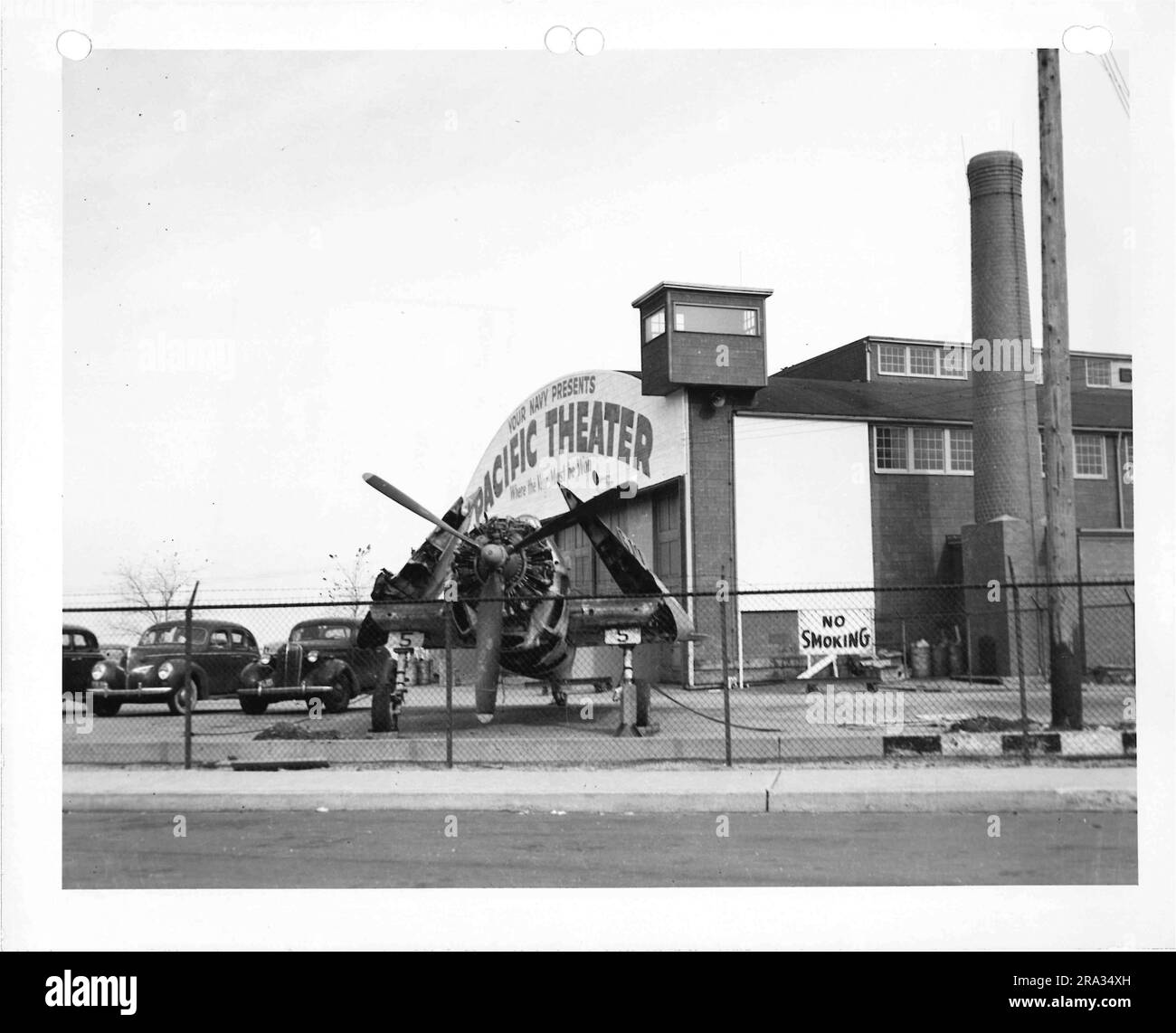 Photograph of Airplane and Three Cars Outside Hangar Stock Photo - Alamy