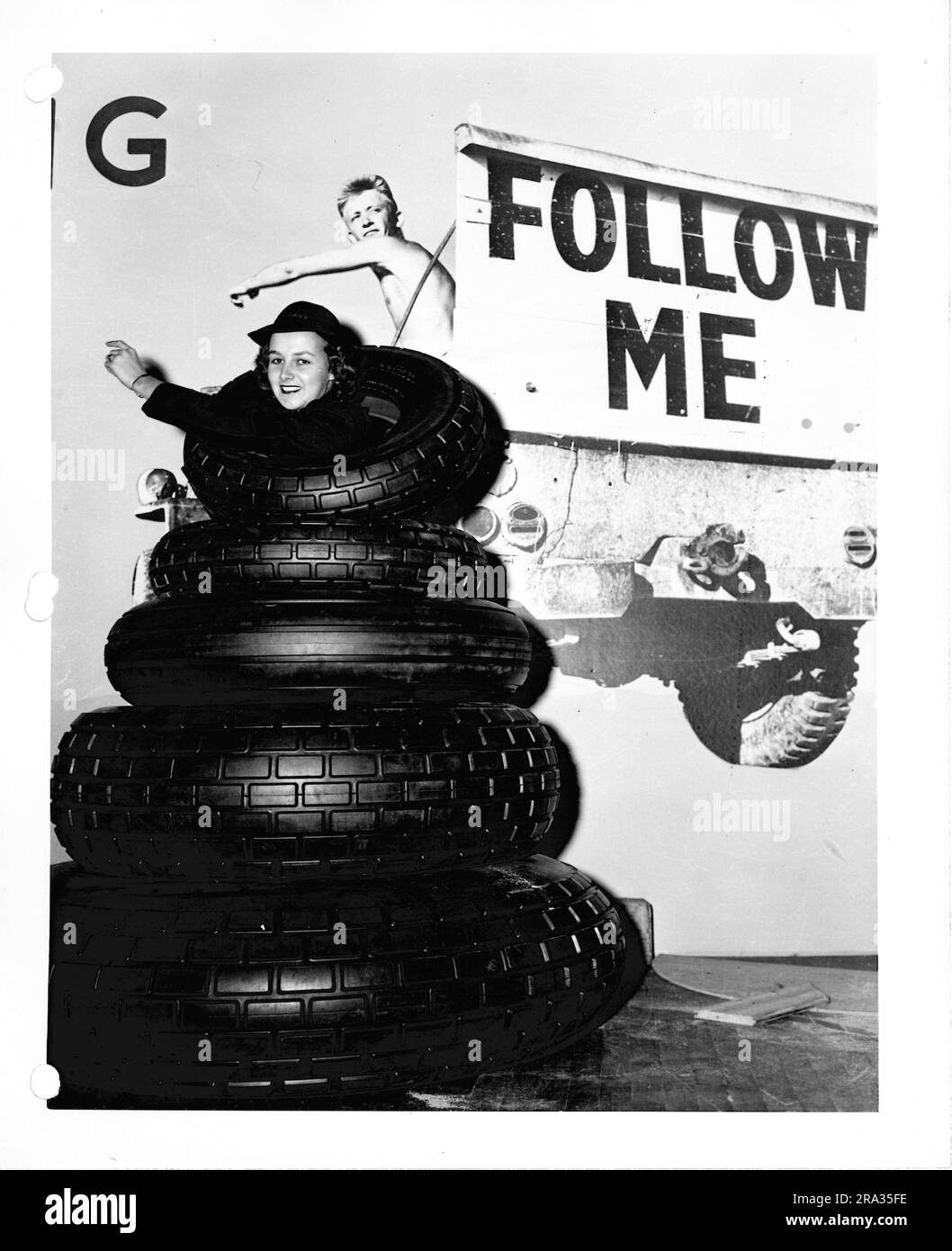 Photograph of Woman Standing in a Stack of Tires Stock Photo - Alamy