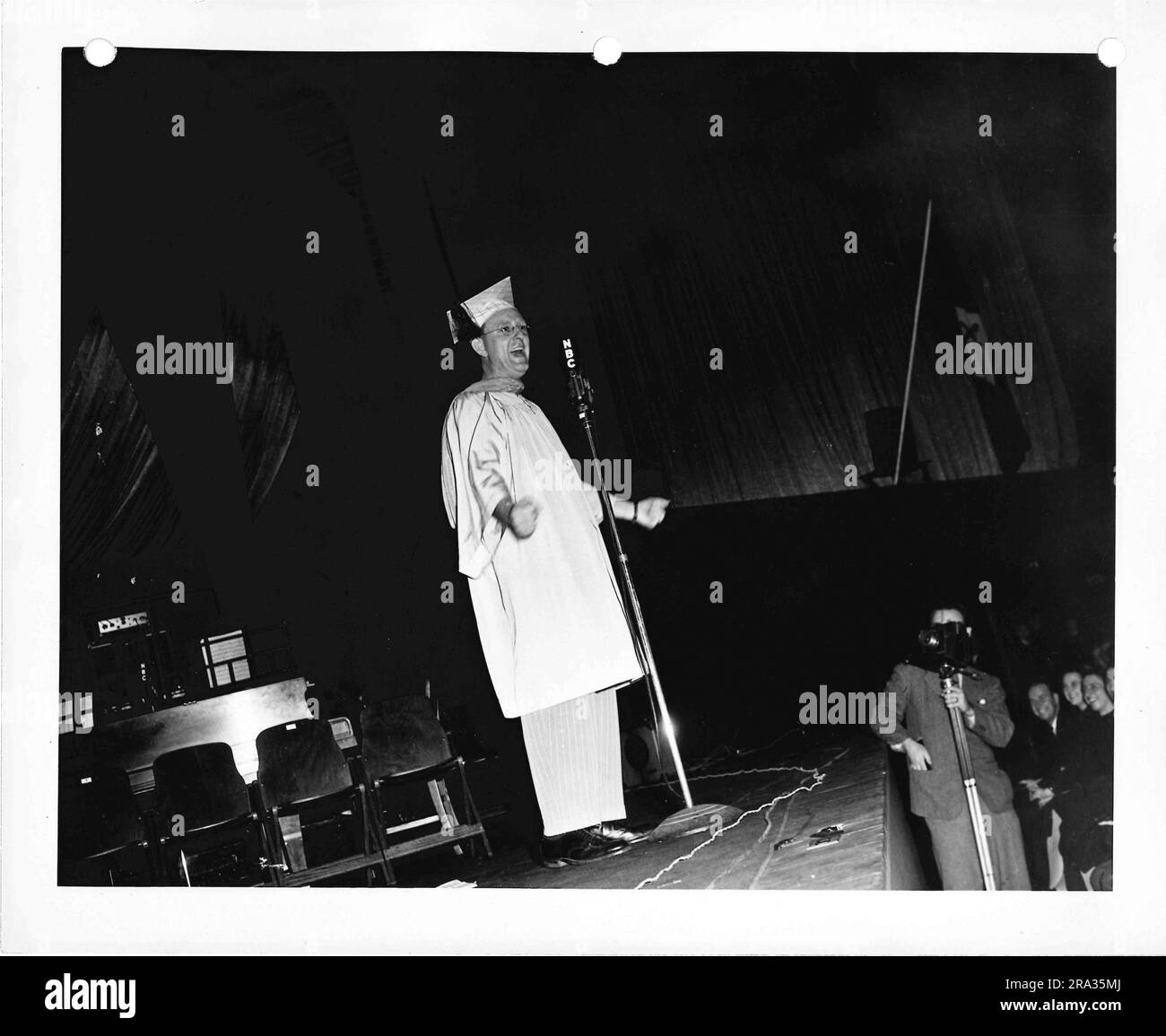 Photograph of Man in Graduation Cap and Gown Talking into NBC ...