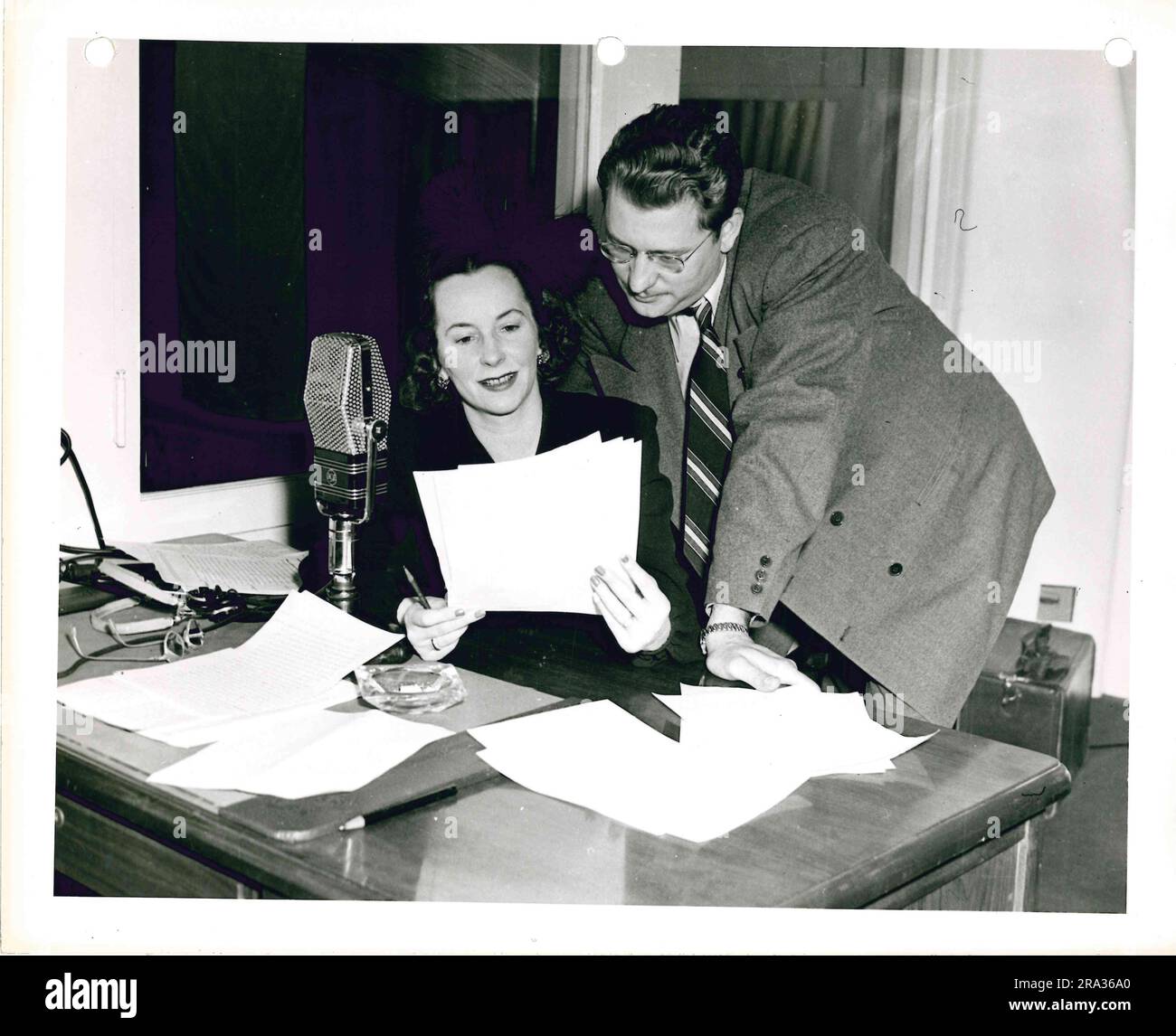 Photograph of Woman and Man Reading Papers in Front of a Desk ...