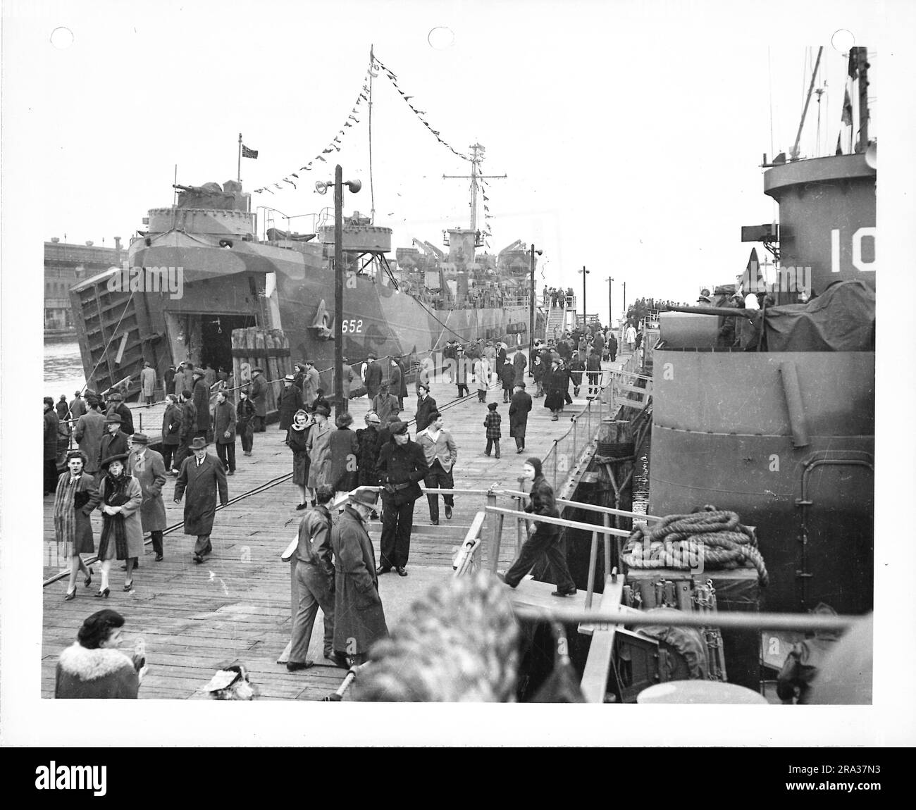 Photograph of Crowded Pier and Military Landing Craft Stock Photo - Alamy