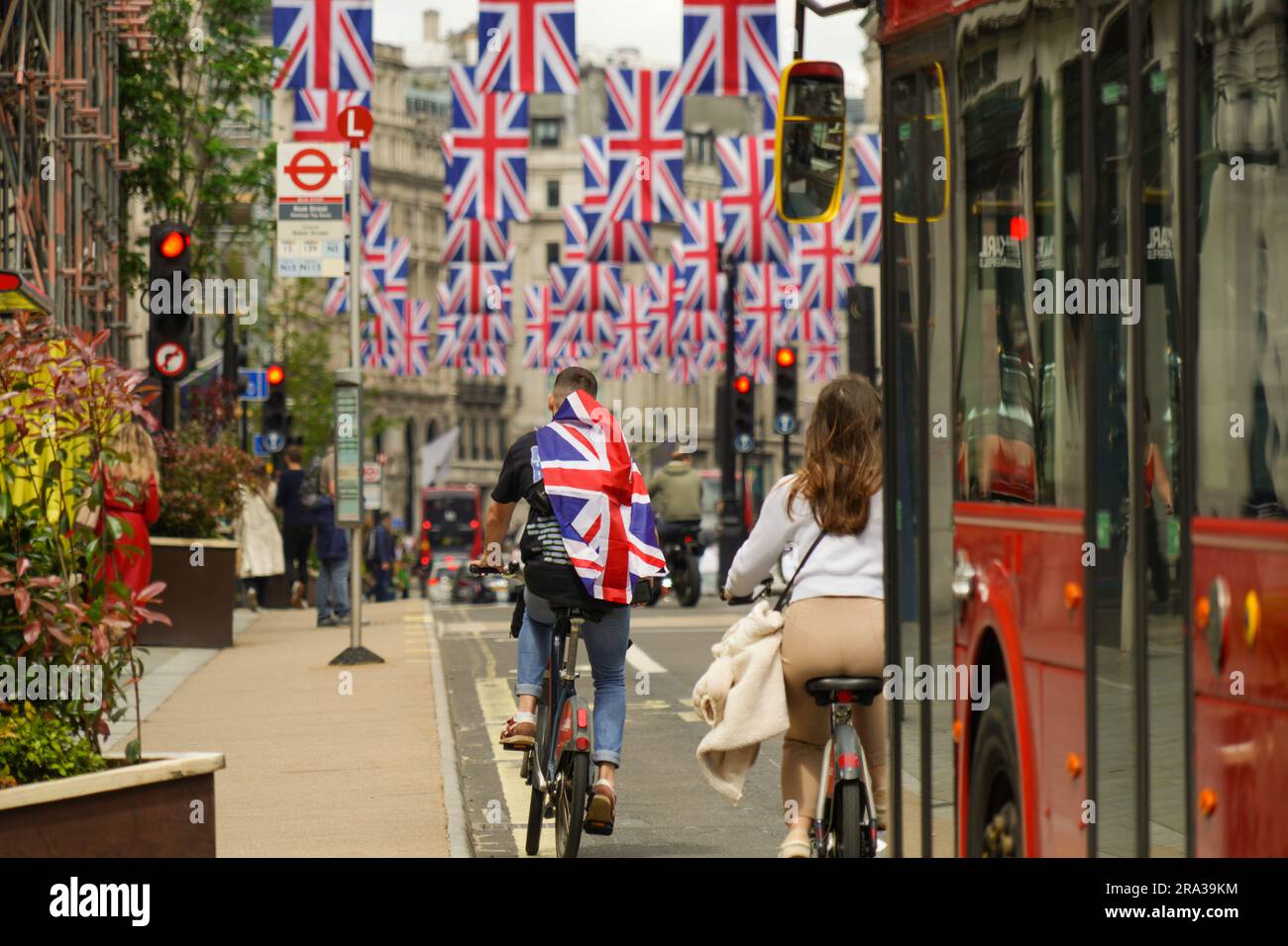 A man draped in a Union Jack Flag shows his pride as he rides a bicycle ...
