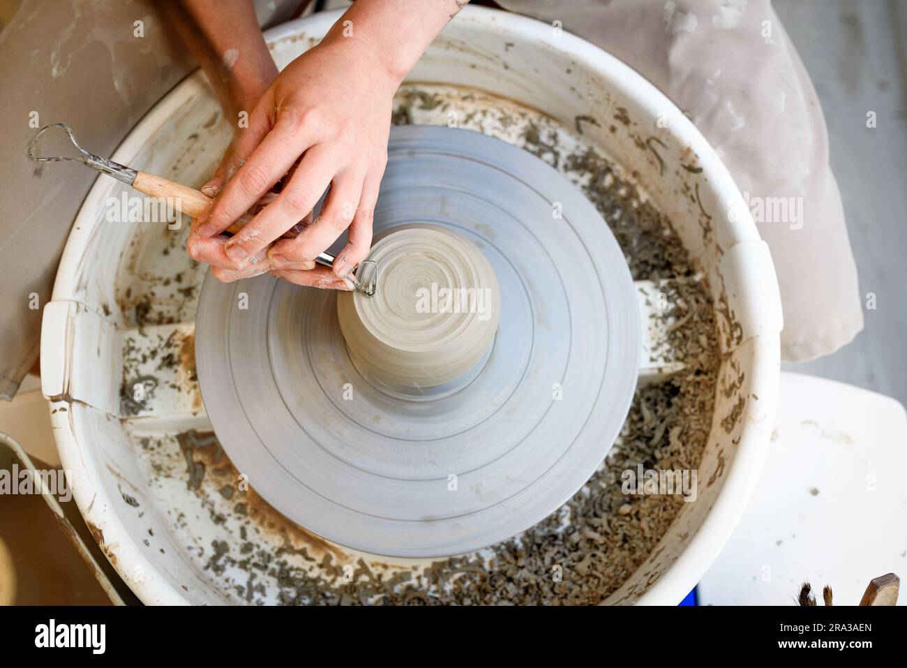 close up of ceramist hands working and shaping ceramic on the lathe or ...