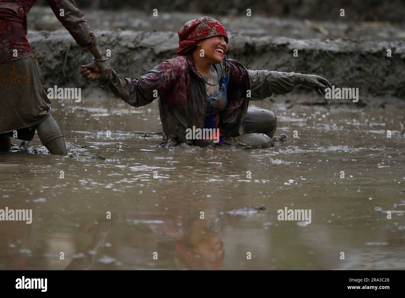 Nuwakot, Nepal. 30th June, 2023. A farmer is helped by another as she ...