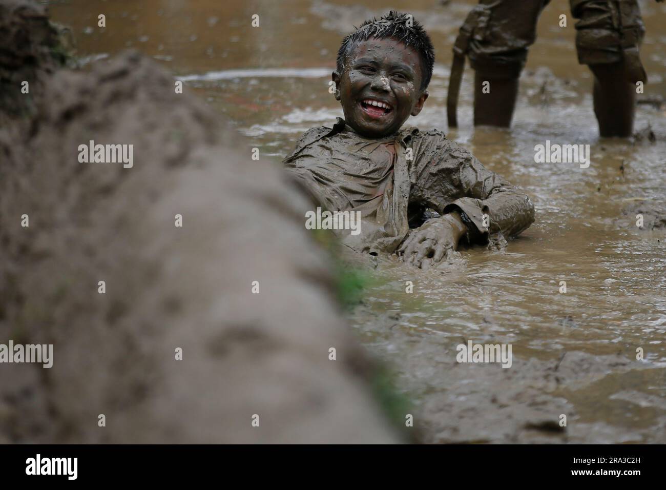 Nuwakot, Nepal. 30th June, 2023. A kid smiles while playing in muddy ...