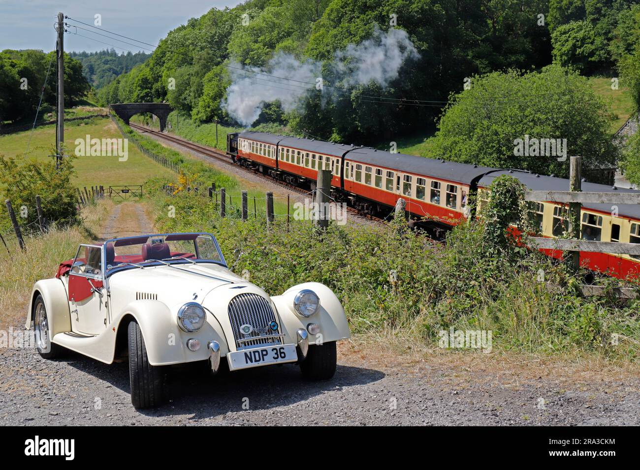 Steam Train and coaches with a Morgan 4/4 Sports Car alongside the ...