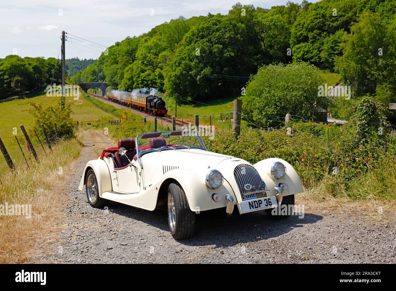 Steam Train and coaches with a Morgan 4/4 Sports Car alongside the ...